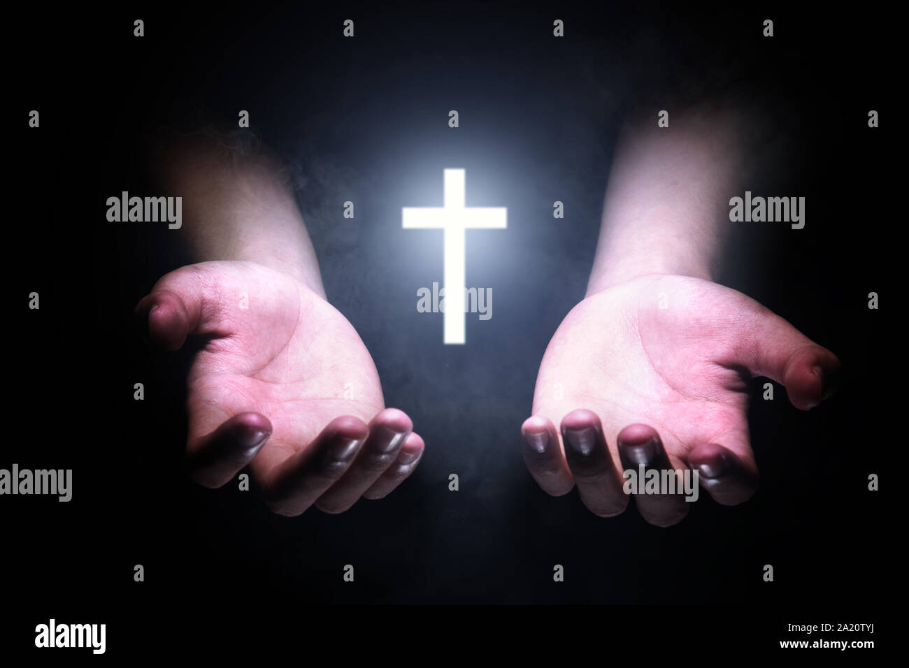 Human hands praying to god with shiny Christian Cross over black background Stock Photo - Alamy