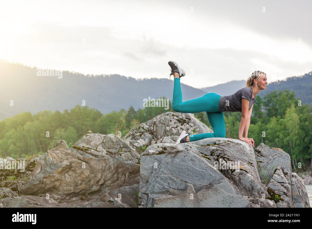 Young woman in green leggins doing the donkey kick exercise on all ...