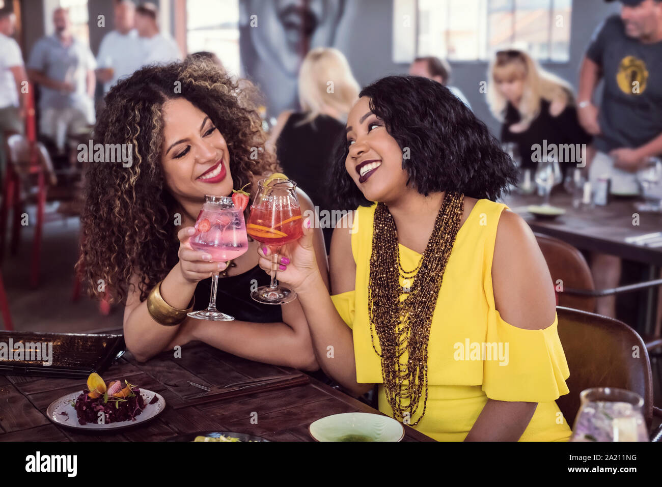 Two women drinking cocktails at Urbanology Stock Photo - Alamy