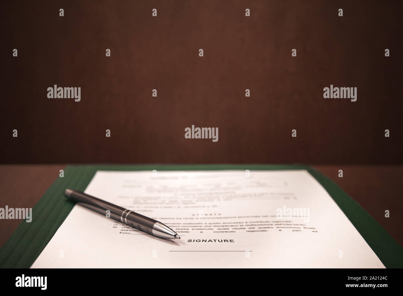 pen with document to be signed, there is an act on a green folder ready ...