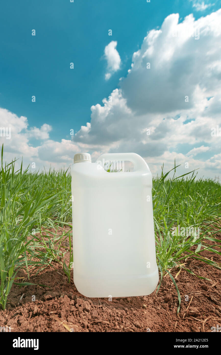 Blank pesticide jug container mock up in wheatgrass field. Using ...