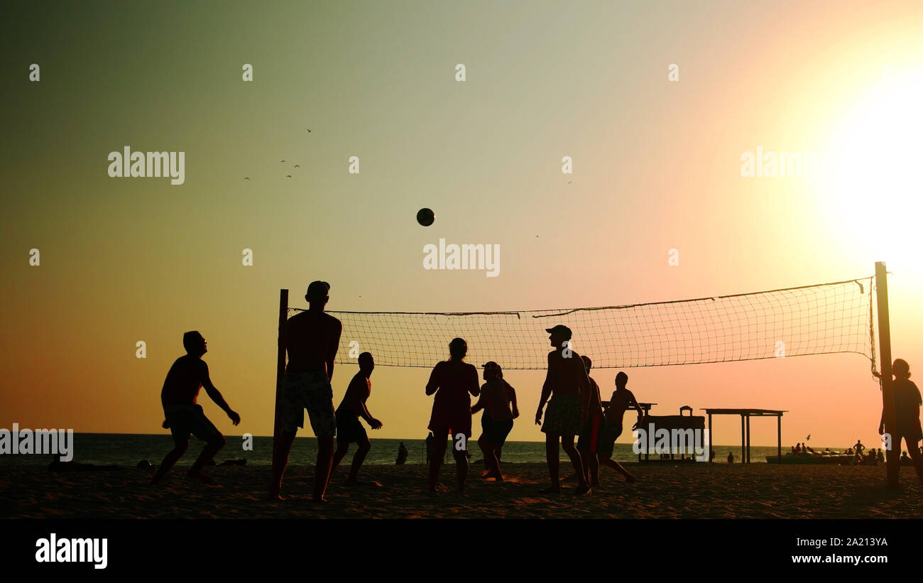 Beach volleyball players at sunset Stock Photo - Alamy