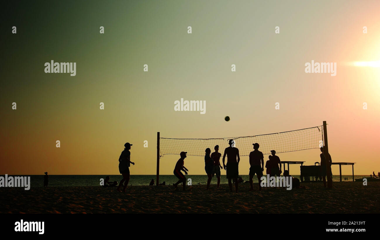 Group of young people playing volleyball on the beach Stock Photo - Alamy