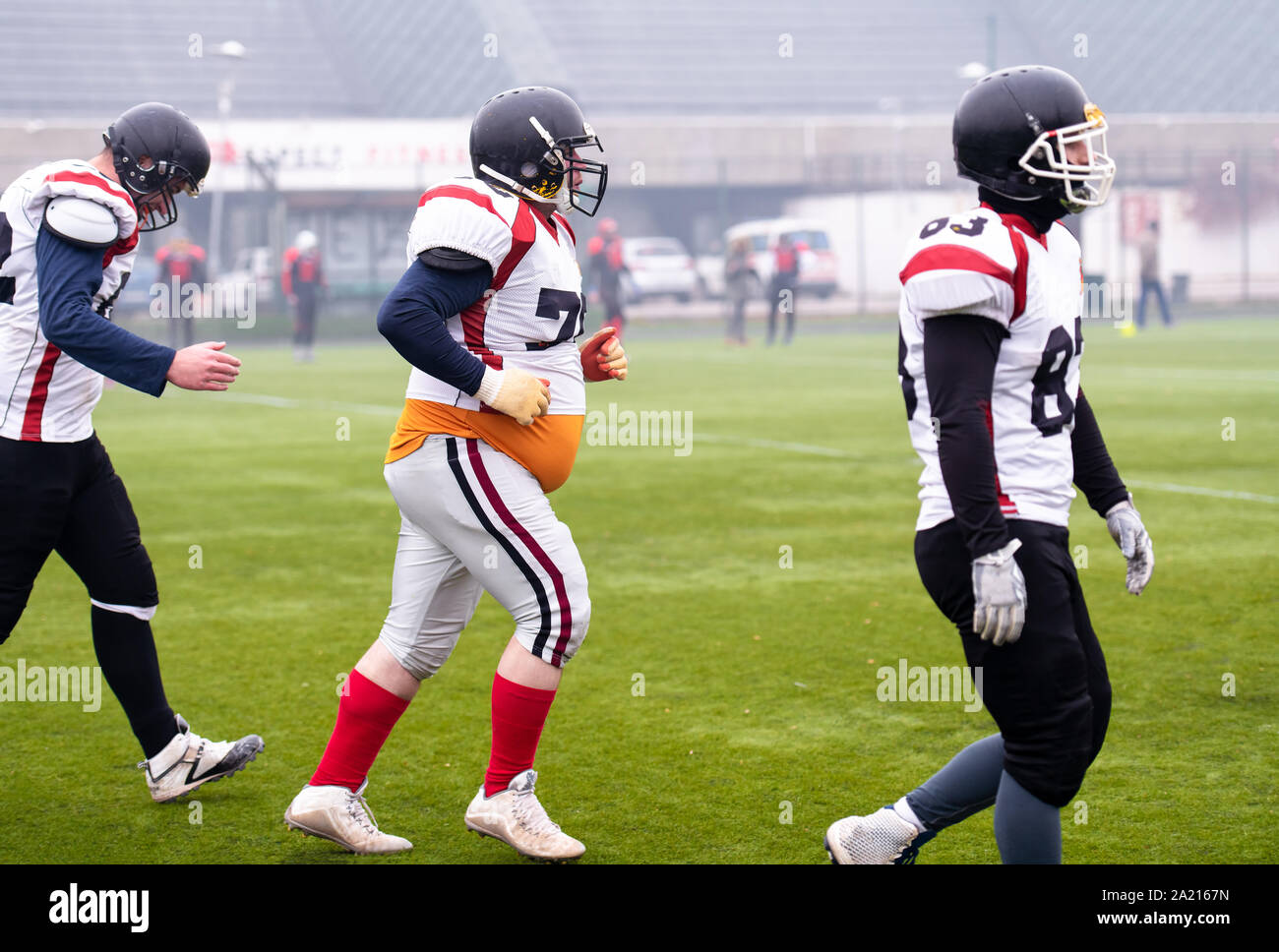 group of young confident American football players walking through the ...