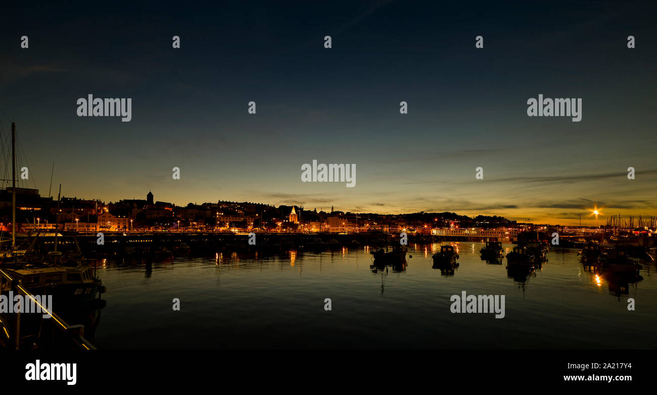 Night scene in St Peter Port harbour on the island of Guernsey; UK ...