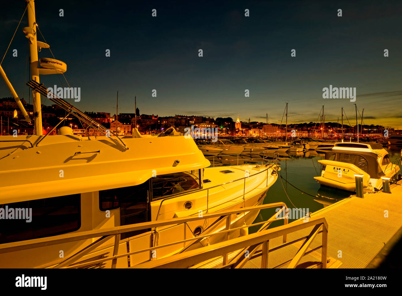 Night scene in St Peter Port harbour on the island of Guernsey; UK ...