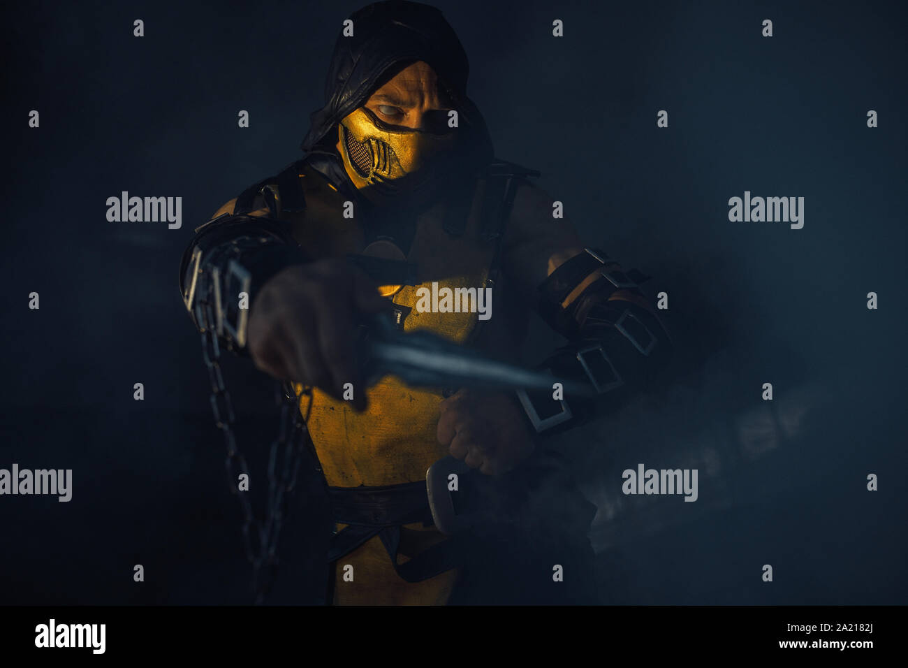 Man portraying Scorpion with dagger in his hand poses at the smoke ...