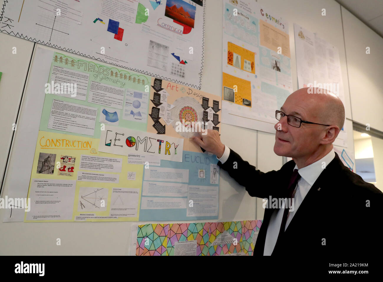 Education Secretary John Swinney views geometry posters on a wall ...