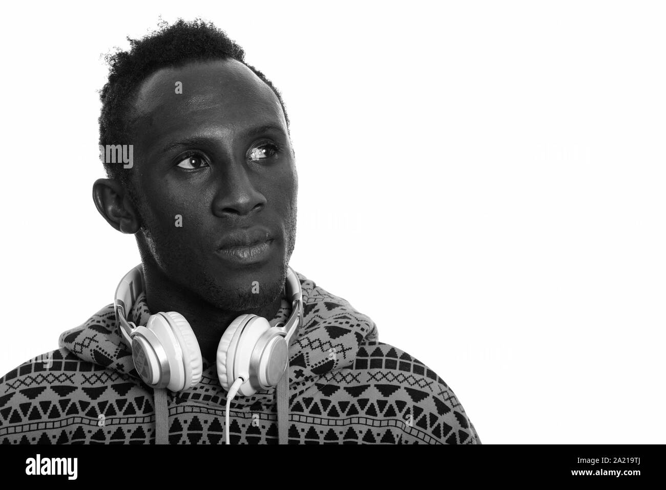Thoughtful young black African man wearing headphones around neck Stock ...