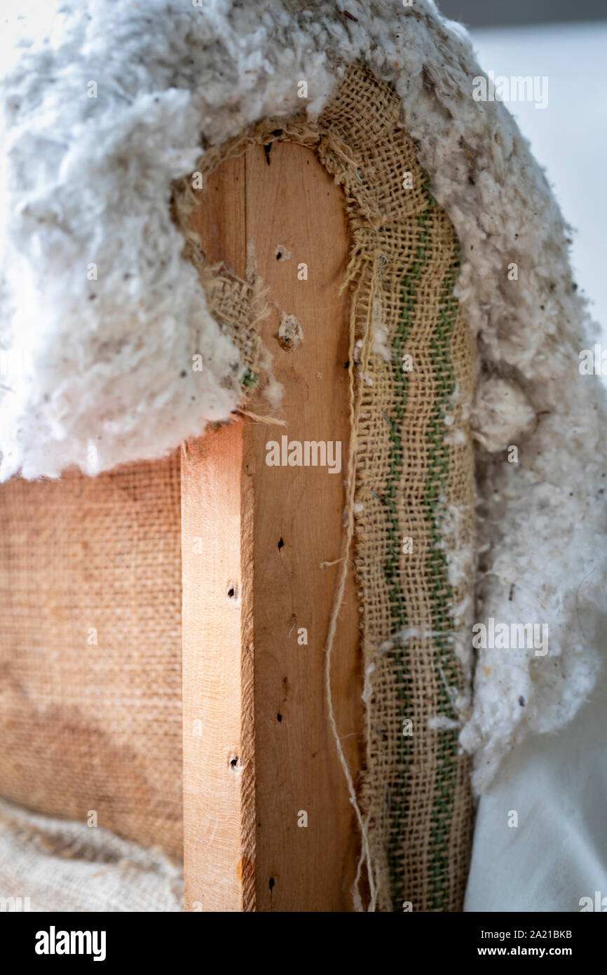 Upholstery materials and equipment, wadding being placed around chair ...