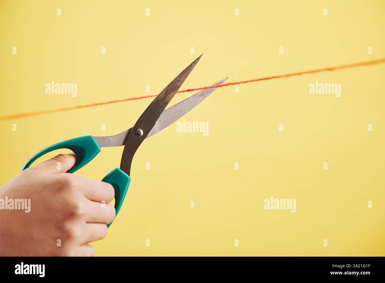 Person cutting thin red thread with sharp scissors Stock Photo - Alamy