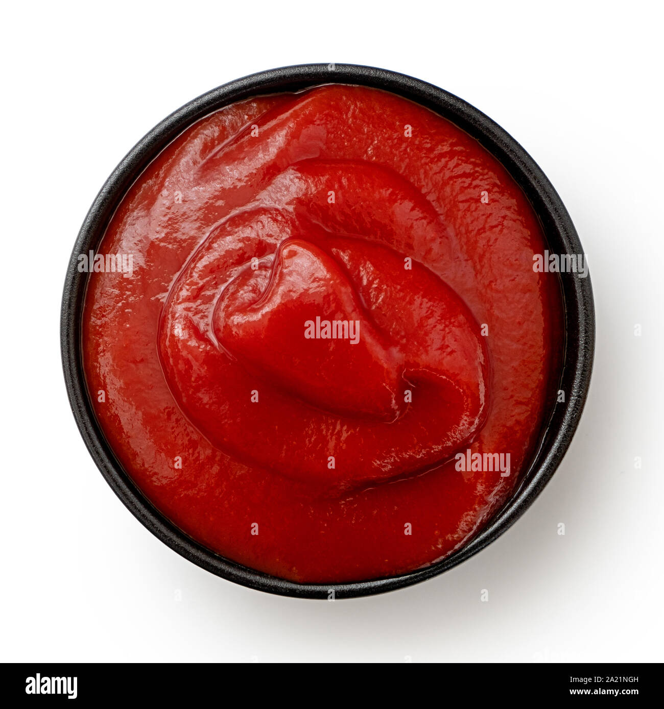 Tomato ketchup in small black ceramic dish isolated on white. Top view ...
