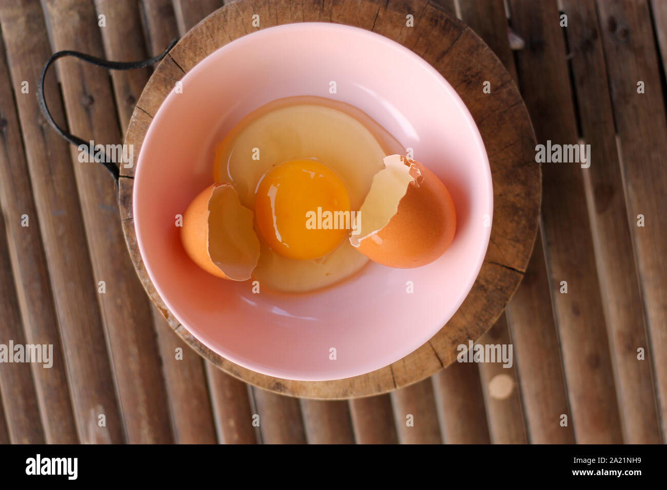 shell with egg and open Eggs in a pink bowl Placed on the butcher on ...