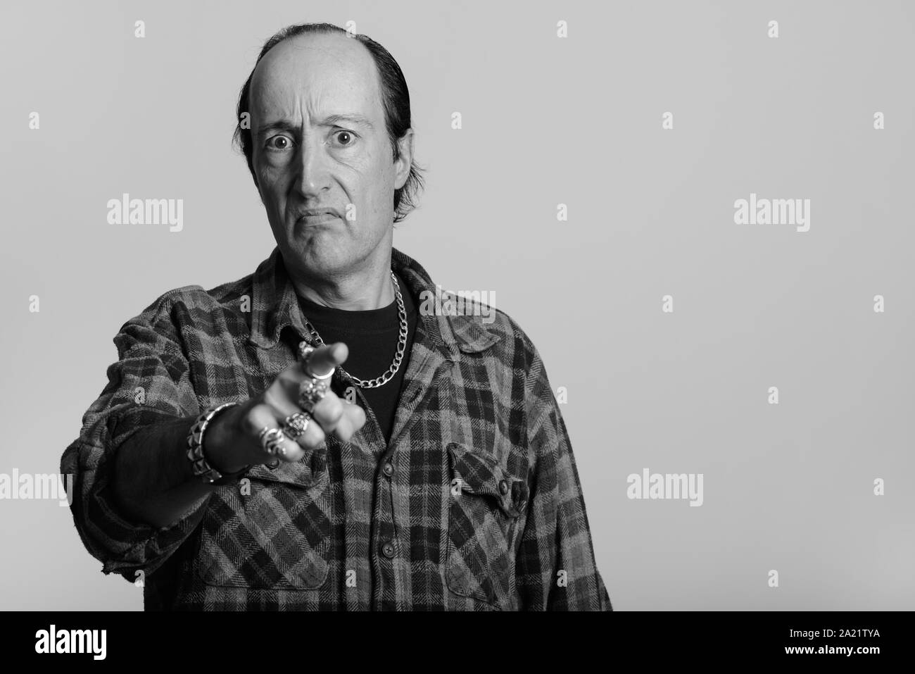 Studio shot of mature gangster man looking angry while pointing finger ...