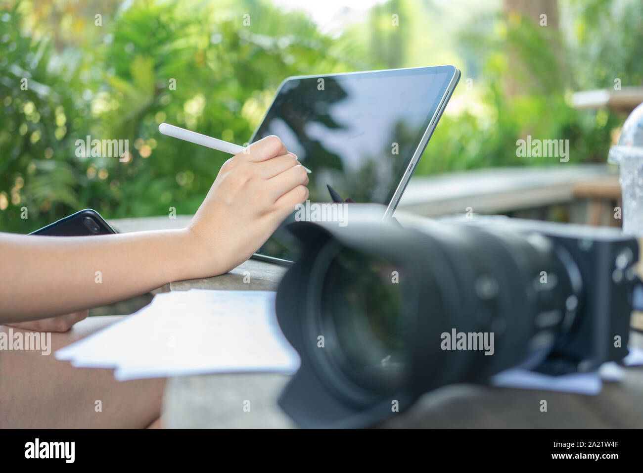 Photographer sitting and editing photos using a tablet. Portable size ...