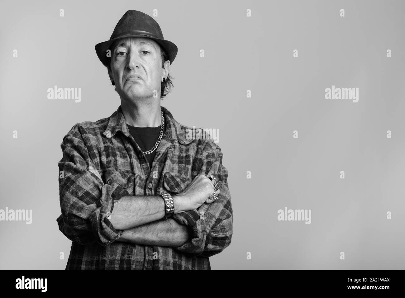 Studio shot of angry mature gangster man with arms crossed Stock Photo ...