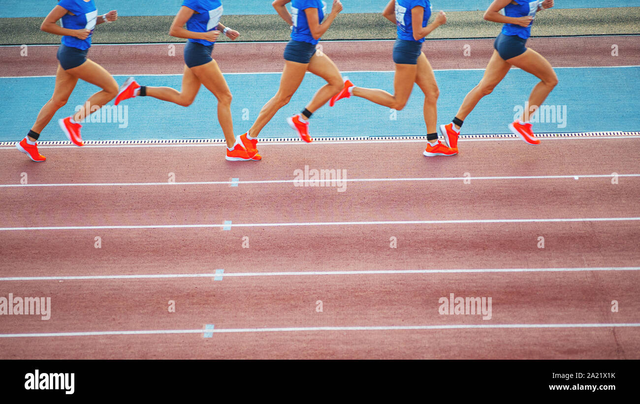 Female athlete runs on the athletic track. Running movement phases ...