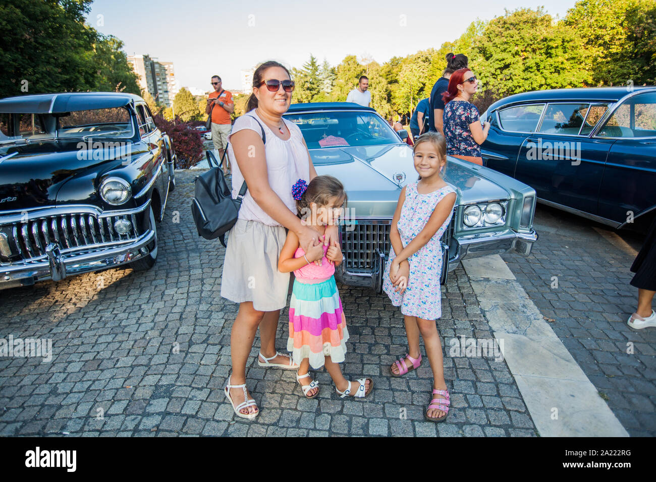 Family portrait at old timer exhibition. Mother and her two daughter at ...