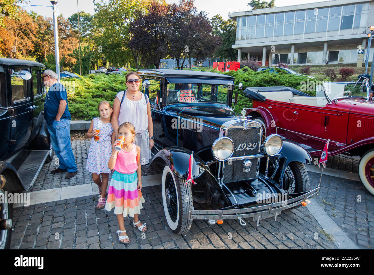 Family portrait at old timer exhibition. Mother and her two daughter at ...