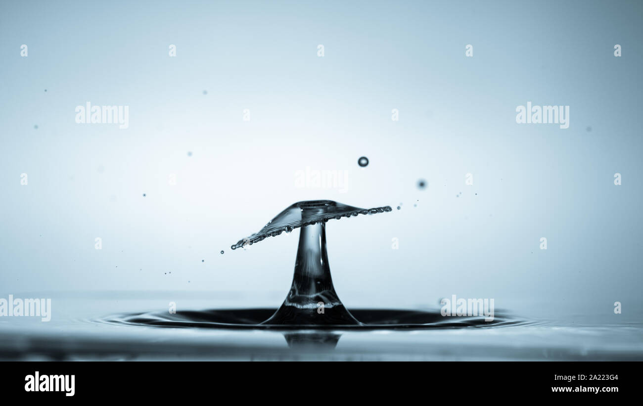 Close-up of a water drop falling on water surface Stock Photo - Alamy