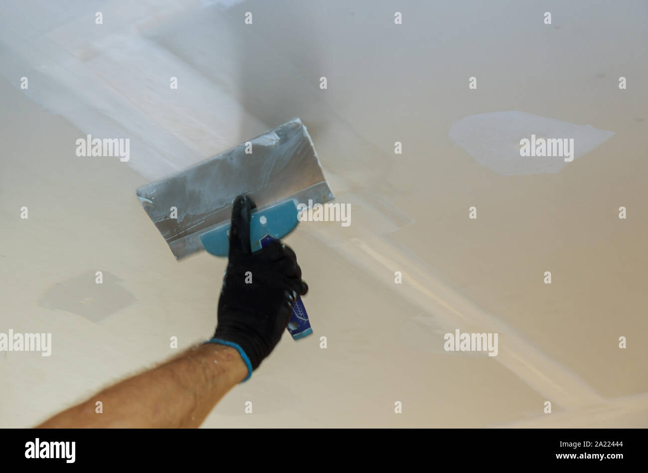 Male builder repairs wall with a spatula plaster on a wall Stock Photo ...