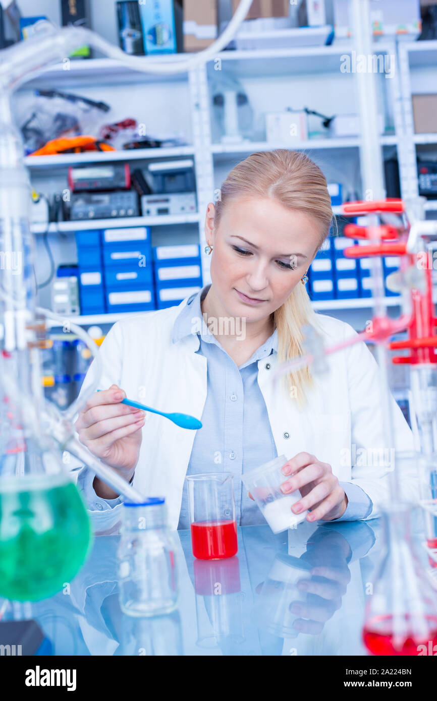 Female laboratory assistant with chemical experiment in scientific ...