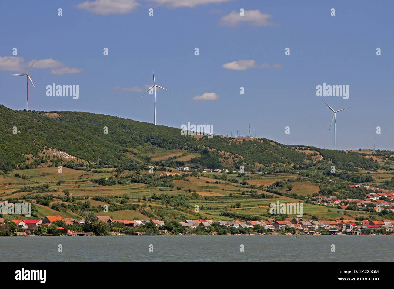 View of Coronini Village and wind turbines on the hill of the Romanian ...