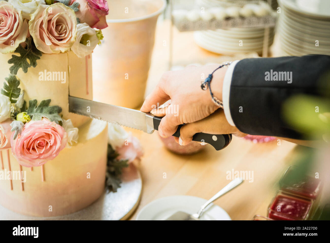 A wedding couple cutting the wedding cake on their wedding day Stock ...