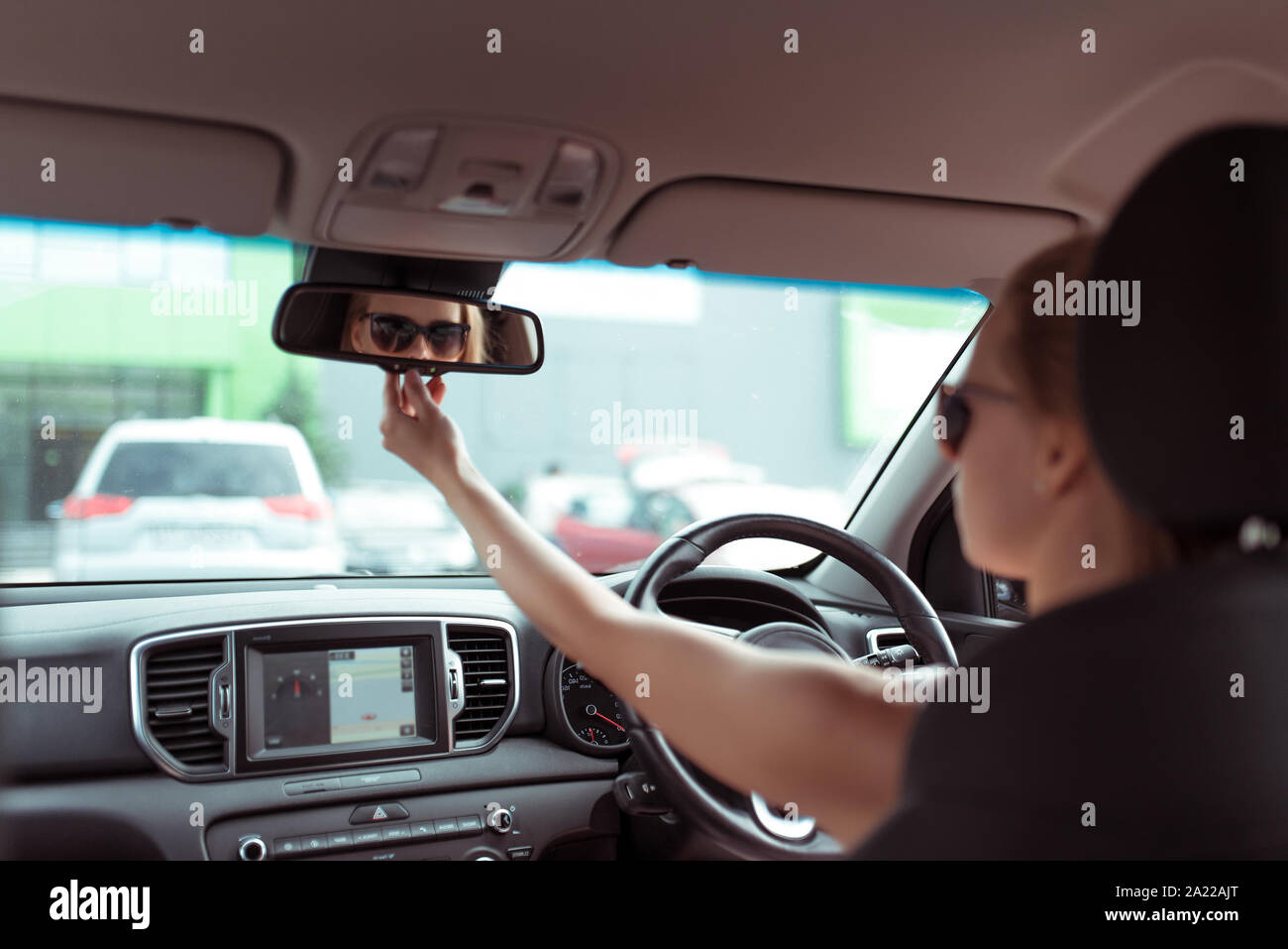 girl in passenger compartment of car looks into bright light of rear ...