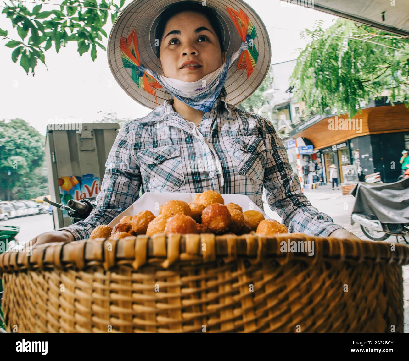 Woman with basket selling traditional vietnams food at the street of ...