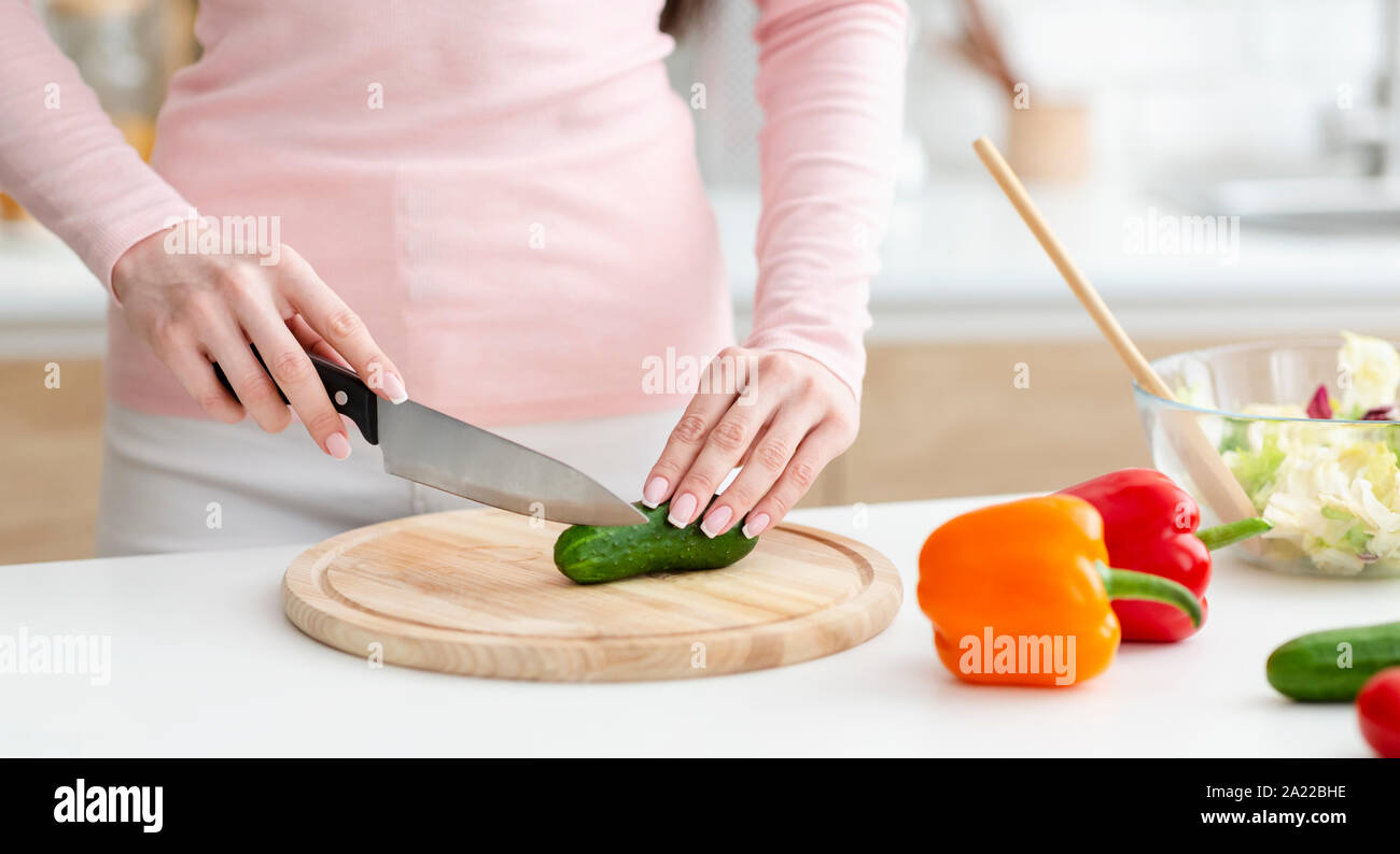 Cooking at home. Woman cutting fresh vegetables for salad on wooden ...