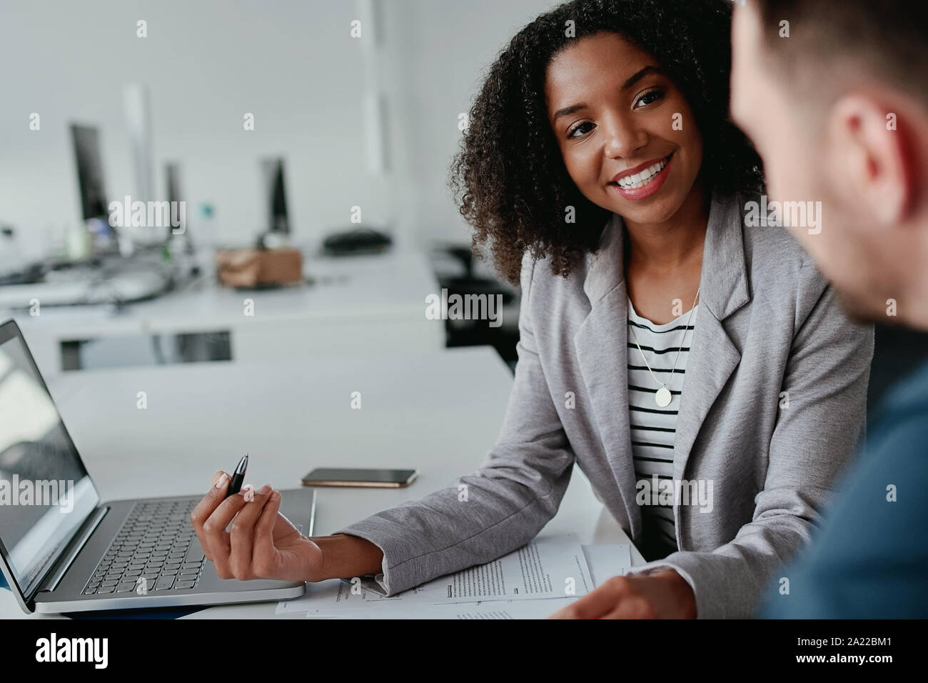 Motivated positive female leader talking with male coworker explaining ...