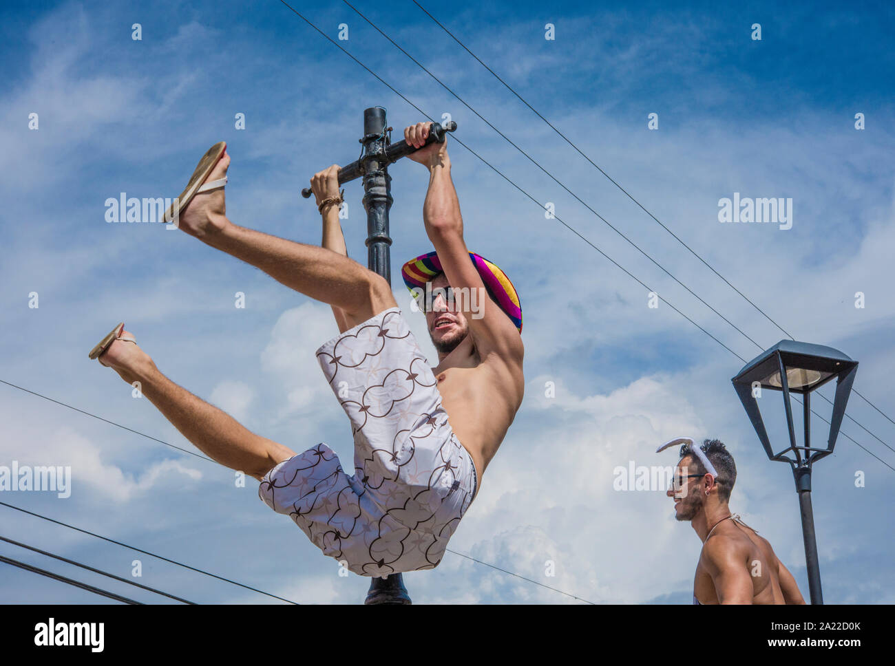 Reveler in carnival hanging on street pole Stock Photo - Alamy