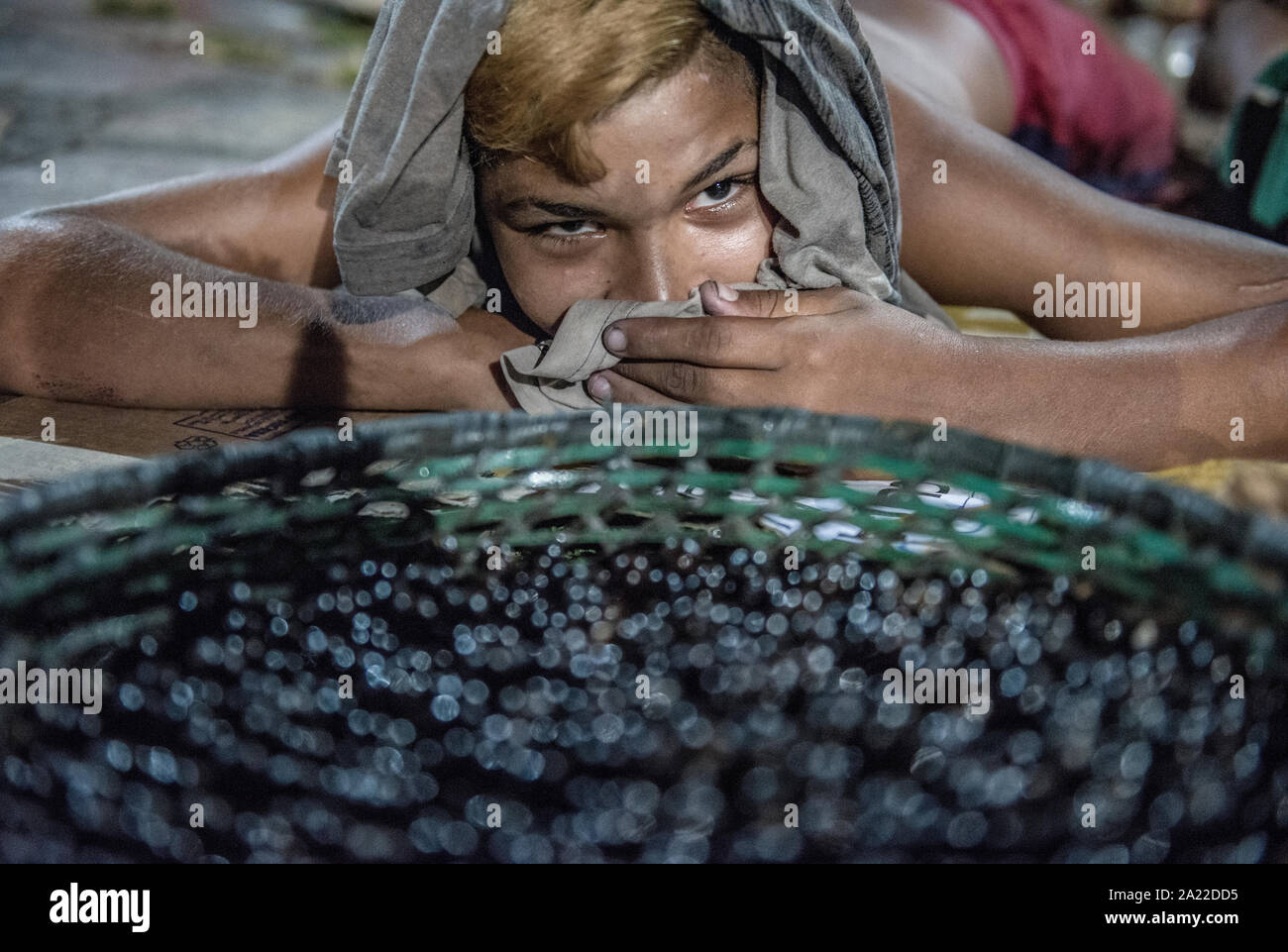 Boy laying on the streets selling acai berries Stock Photo - Alamy