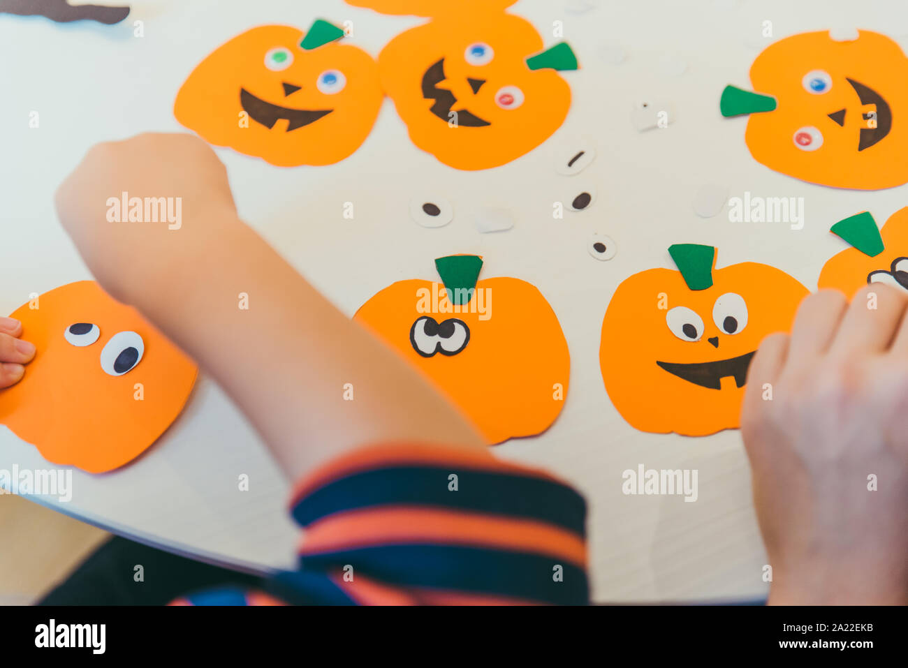 little boy making pumpkins head from paper halloween holidays Stock ...