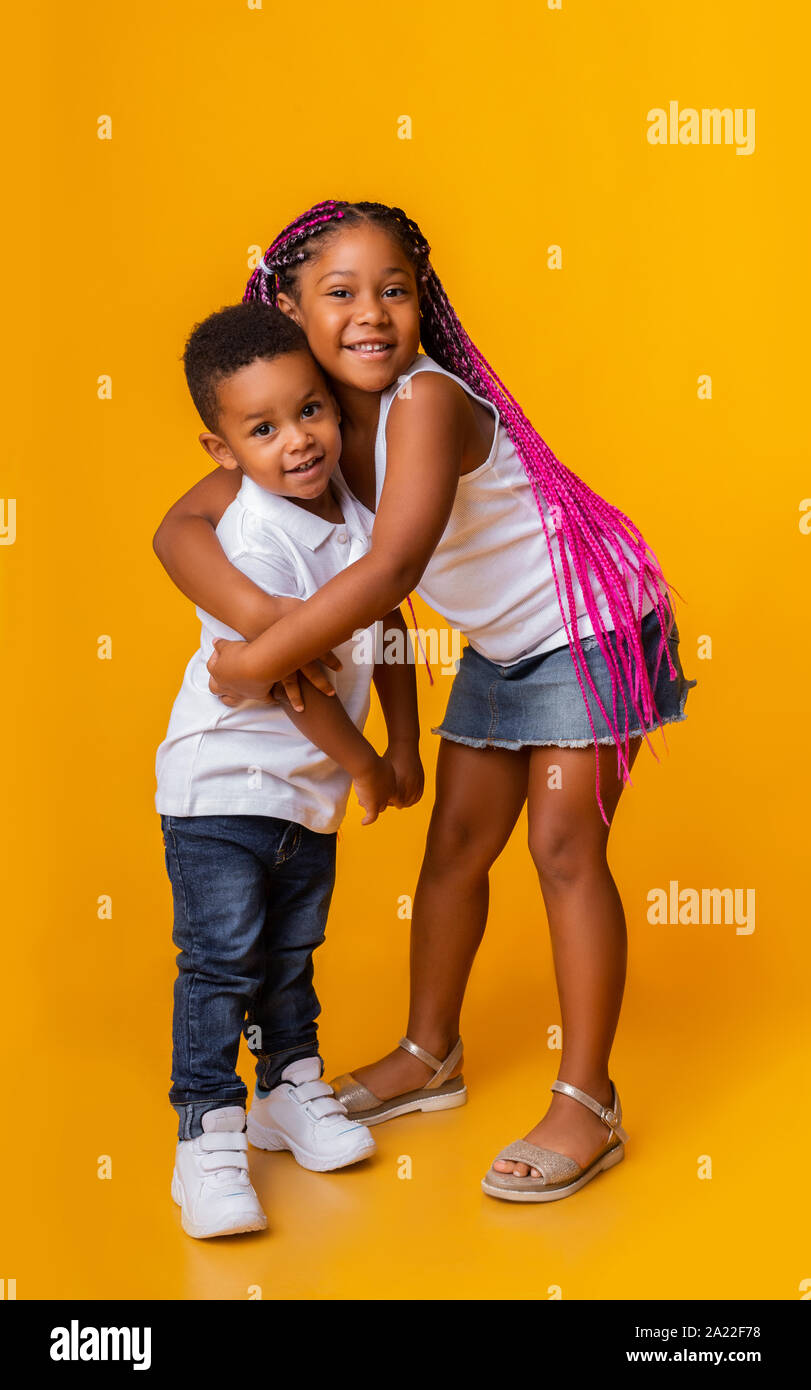 Brother and sister. Cute african american siblings cuddling and smiling ...