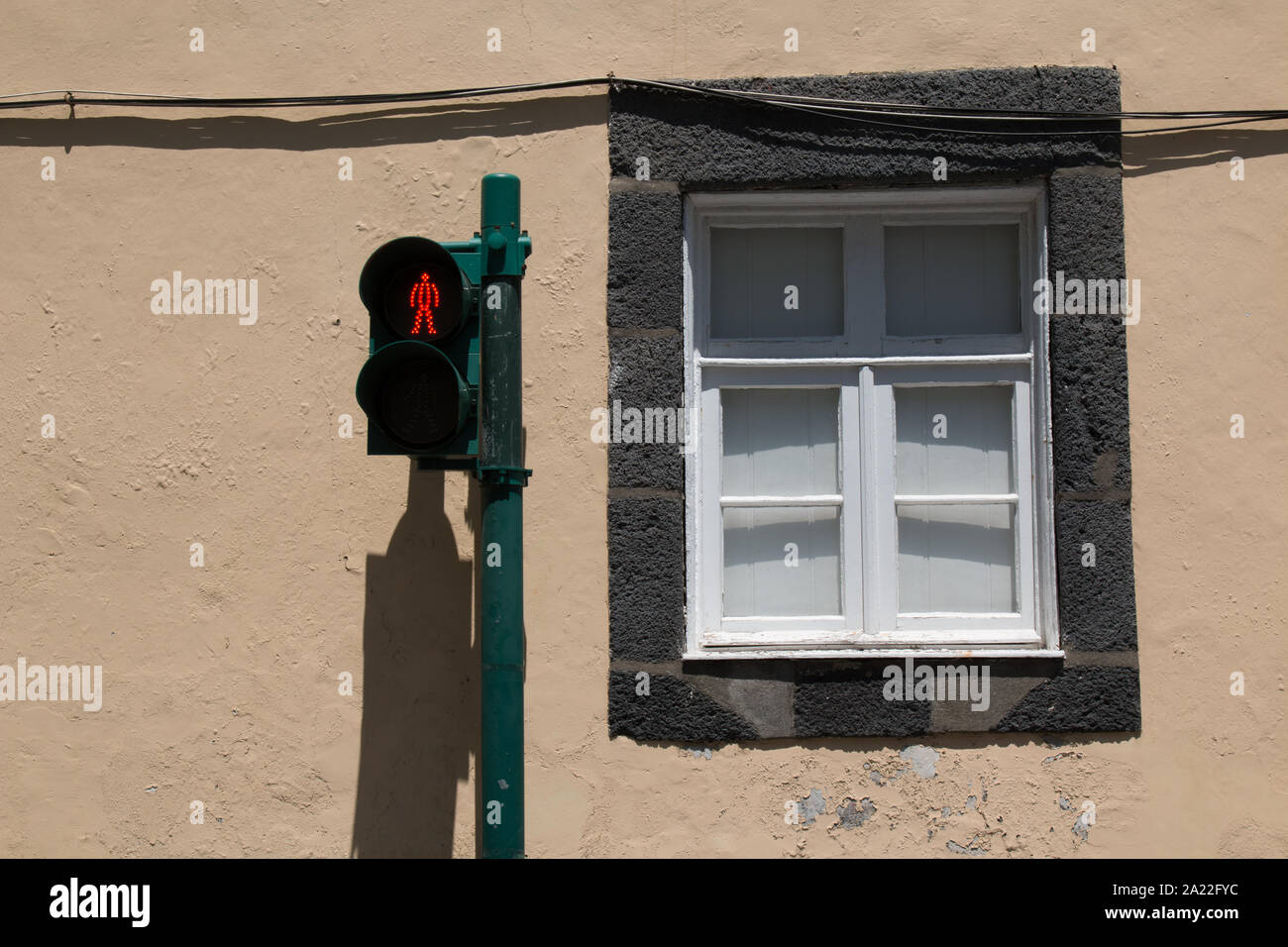 Orange older facade of a traditional house with a window. Traffic light ...