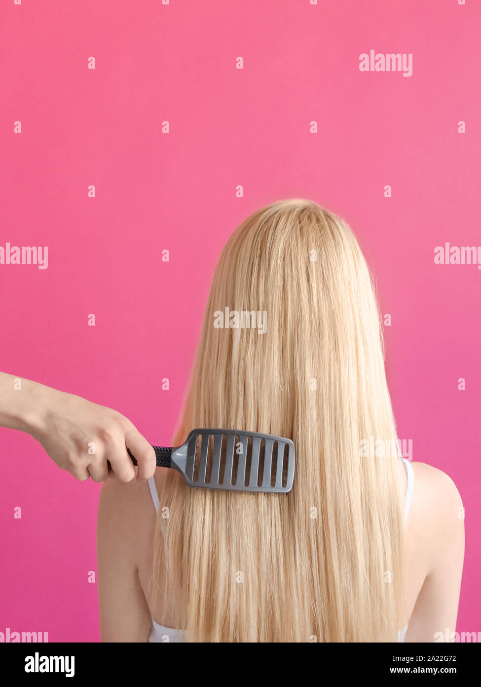 Combing hair Beauty concept Woman's hand is combing long blonde hair ...