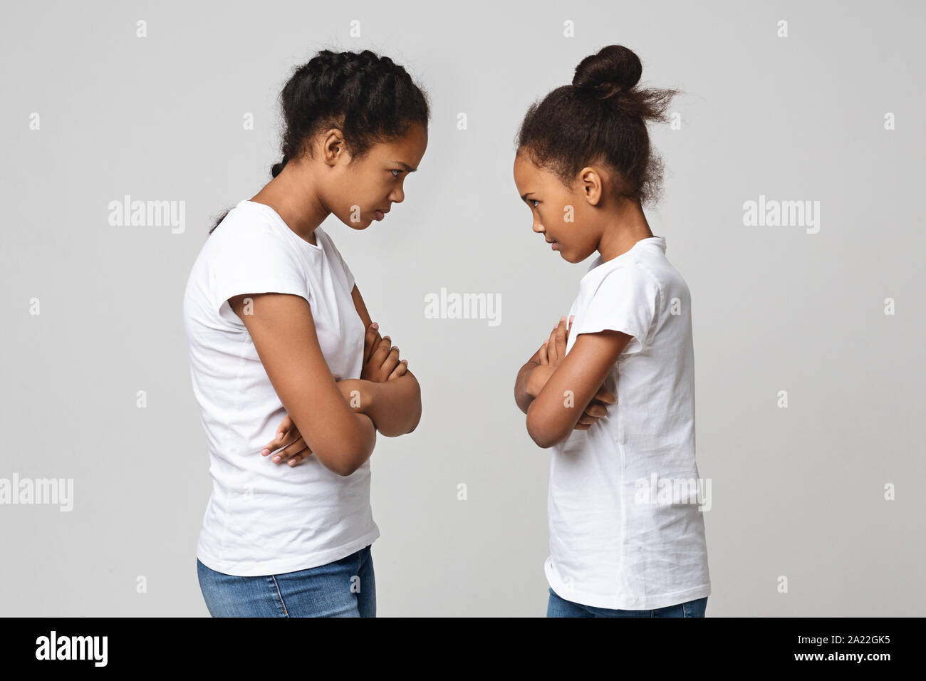 Angry african sisters madly looking at each other with arms crossed ...