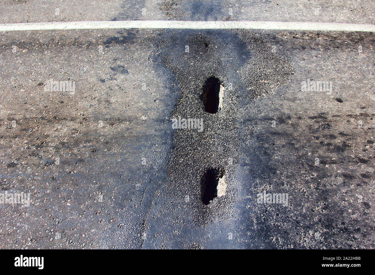 A pot hole in the asphalt road in need of maintenance. The danger of ...