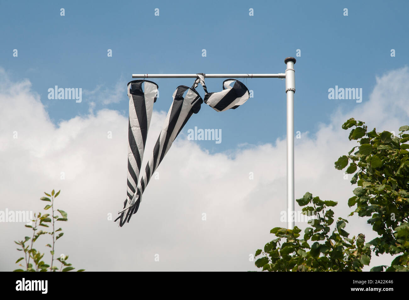 cone shaped wind sleeves of black and white striped fabric hanging at a ...