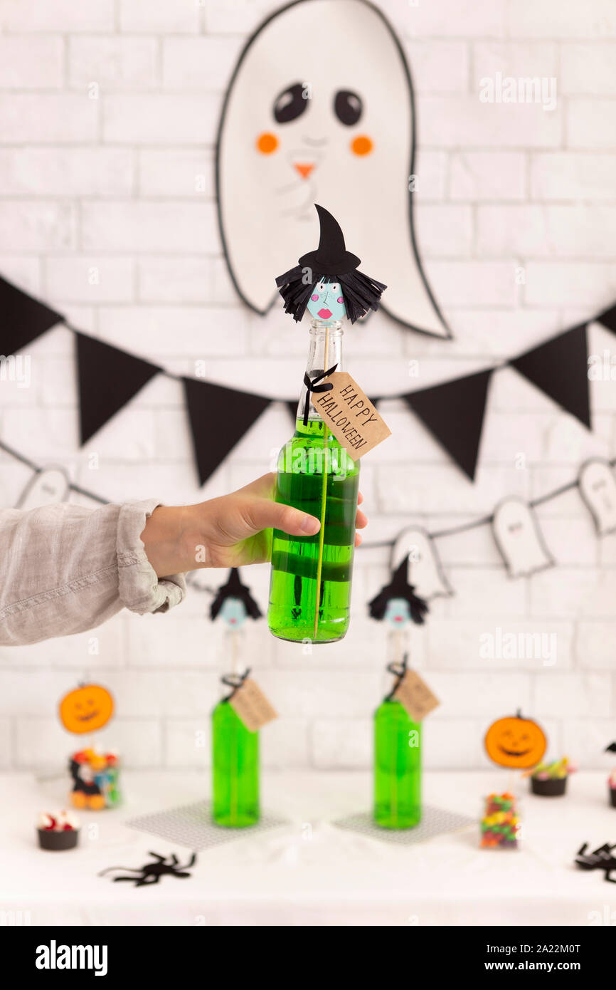 Halloween concept. Woman holding green toxic drink in hand over ...