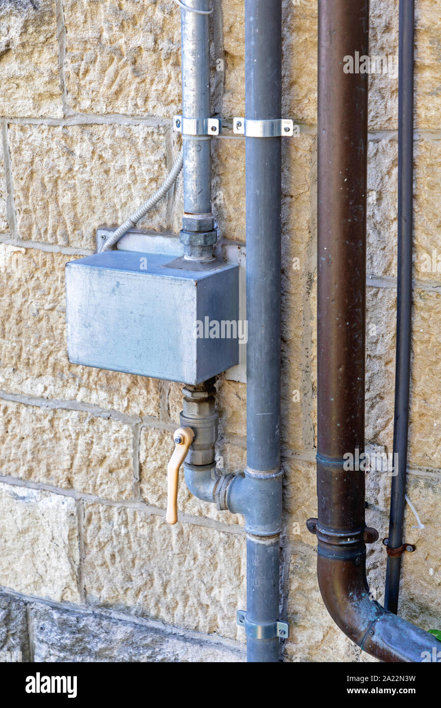 Many Water Pipes and Box at Stone Building Exterior Stock Photo - Alamy