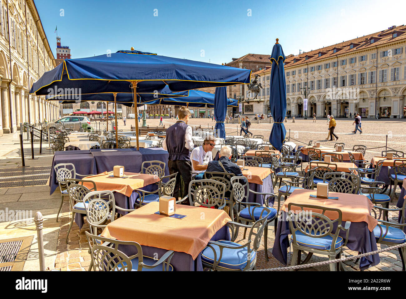 A waiter serves coffee at a restaurant in the elegant Baroque Piazza ...