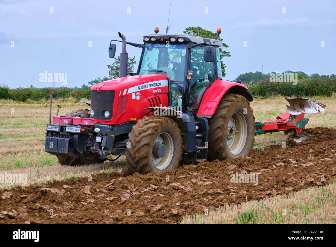 Red Massey Ferguson 6490 agricultural tractor cultivating in a stubble ...