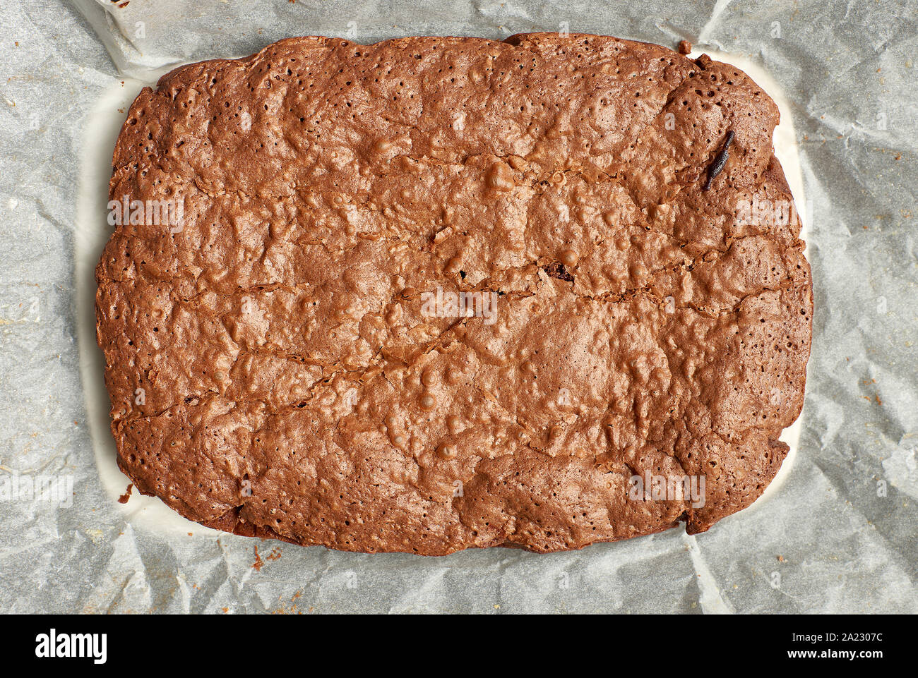 rectangular baked brownie chocolate cake with cracked surface on white ...