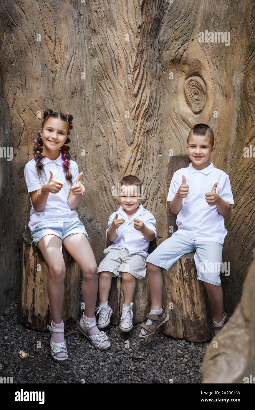 emotional children sitting on stumps Stock Photo - Alamy