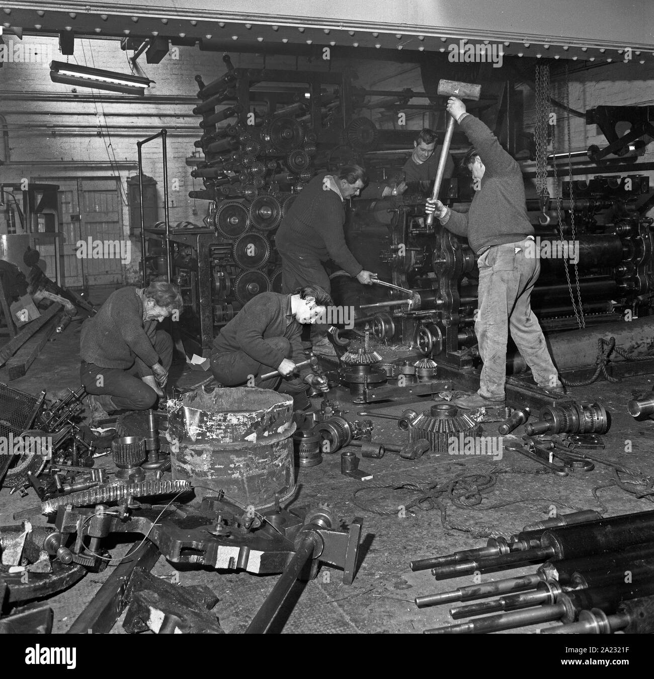 Scrap metal merchants dismantling old newspaper press machine presses ...