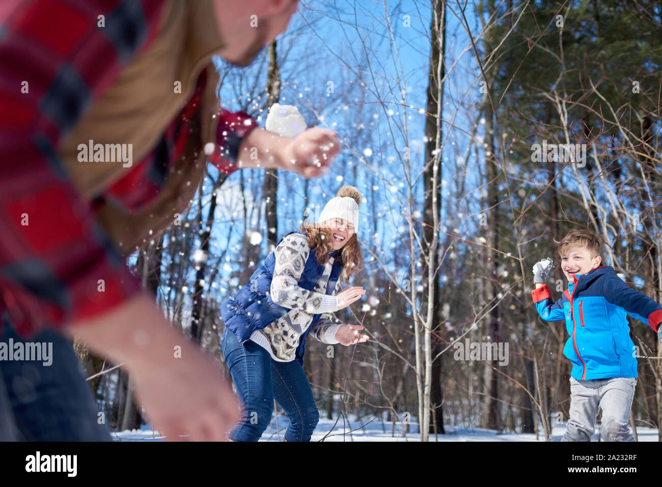 Family of a mother, father and boy child having fun in snow during the ...