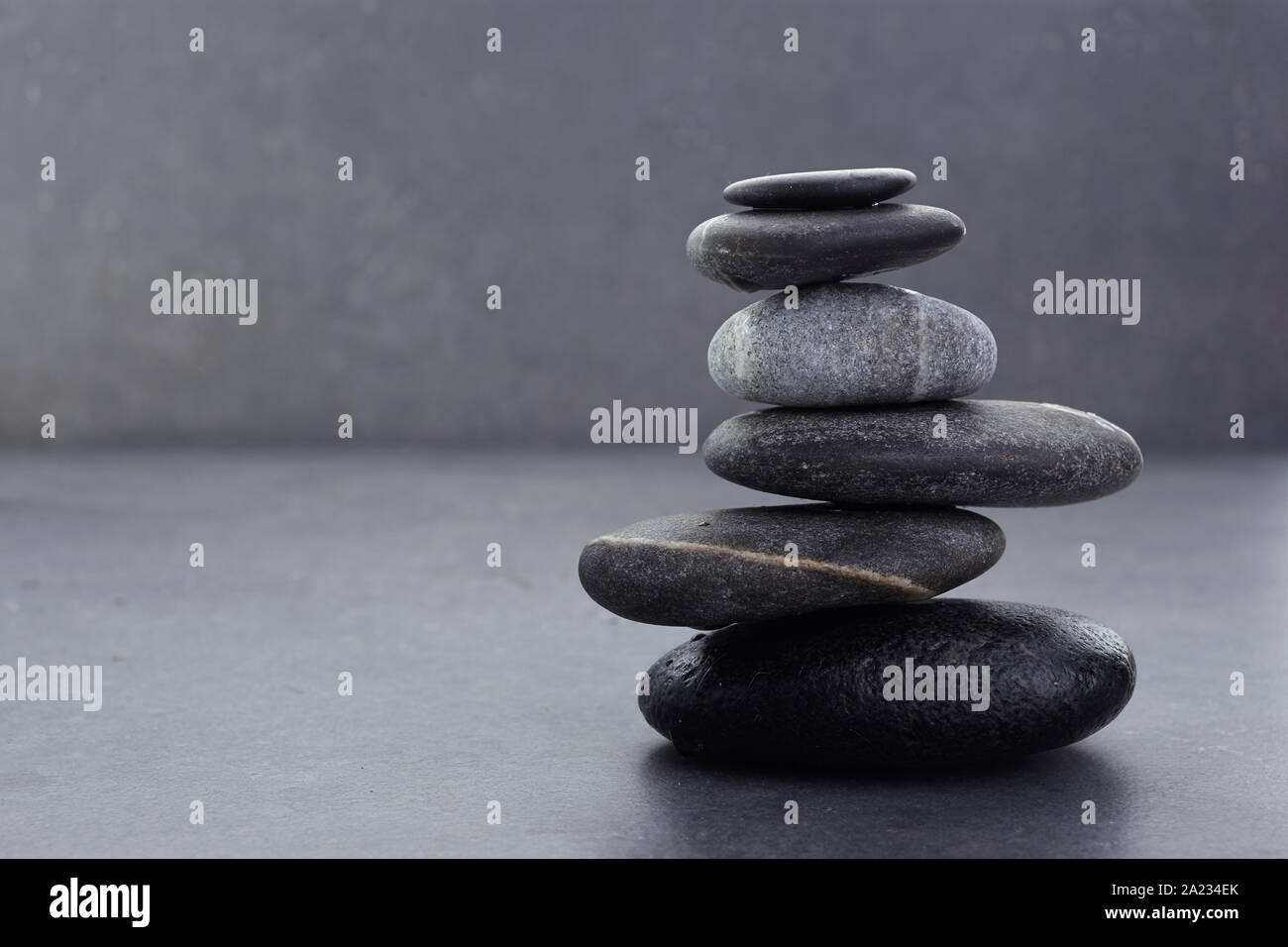 stones in balanced pile on dark grey background Stock Photo - Alamy